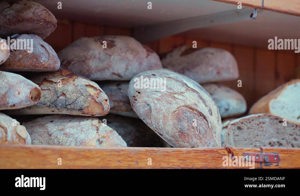 Wooden shelves full of crispy bread loaves in small local bakery store ...