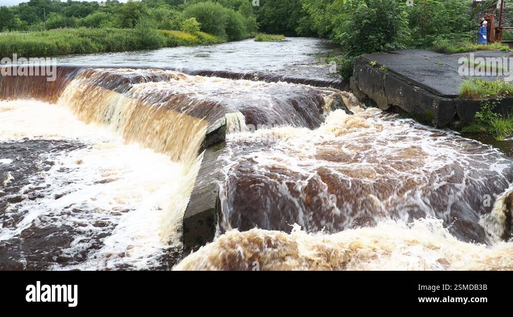 Peat stained water going over a weir in the River Ribble after heavy ...