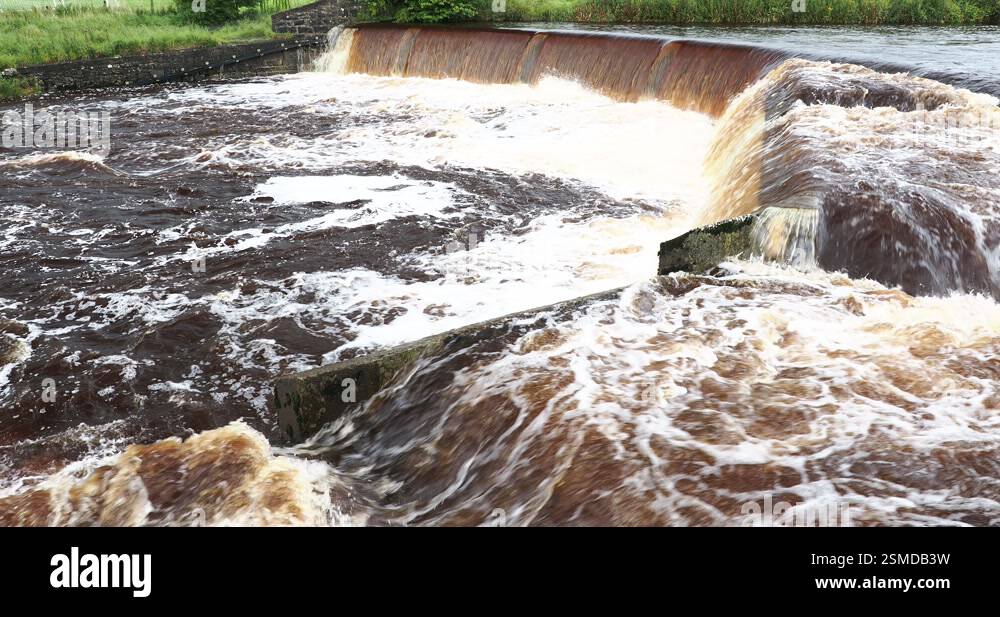 Peat stained water going over a weir in the River Ribble after heavy ...