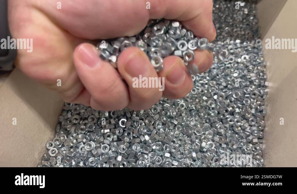 Close-up of a man's hand showing stainless hex nuts, close-up Stock ...