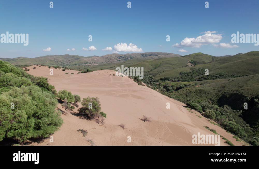 Sandy slope dips below into deep grassy valley on island of Lemnos ...