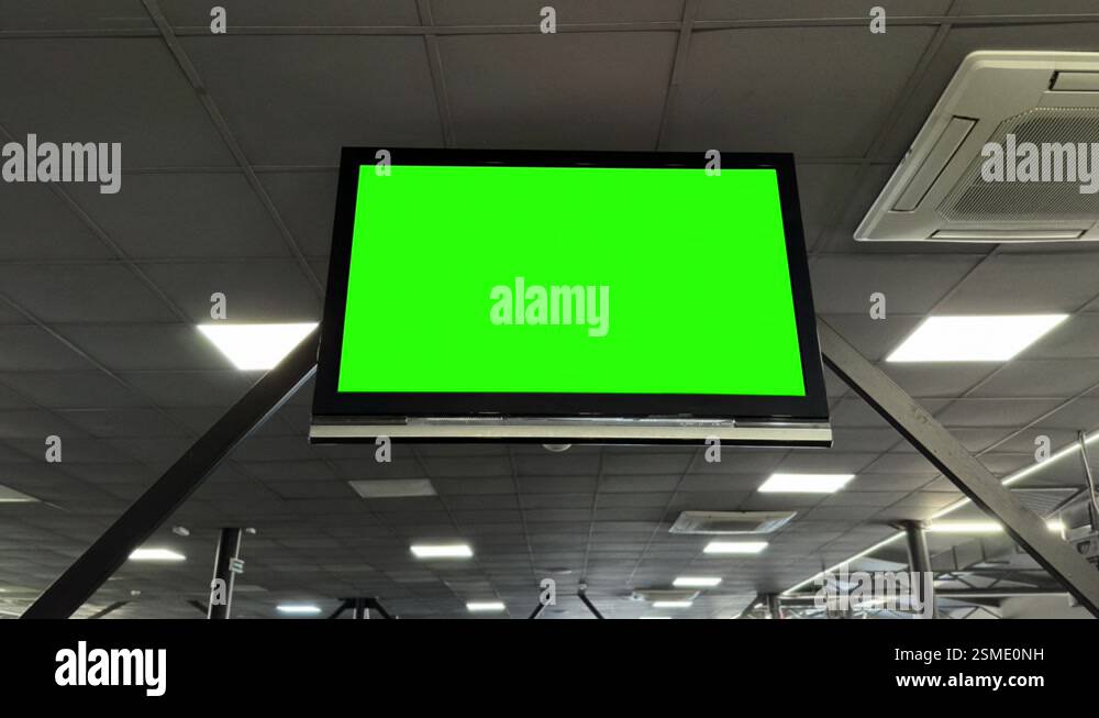Chromakey green screen on a flat-screen TV, ceiling-mounted in a gym ...