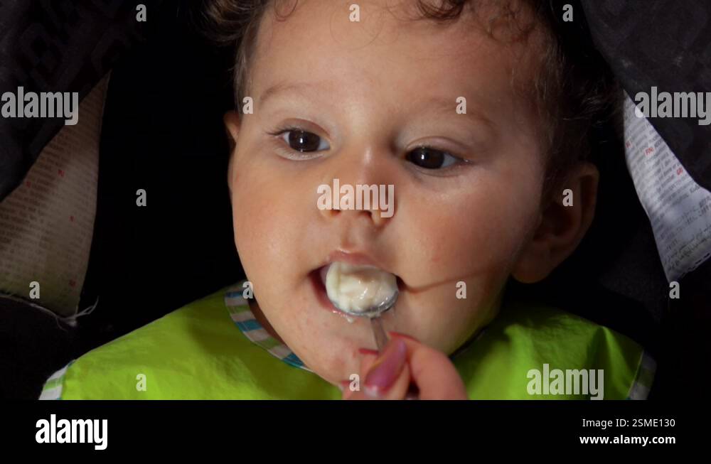 Curly hungry baby boy cries and eats mashed vegetables Stock Video ...