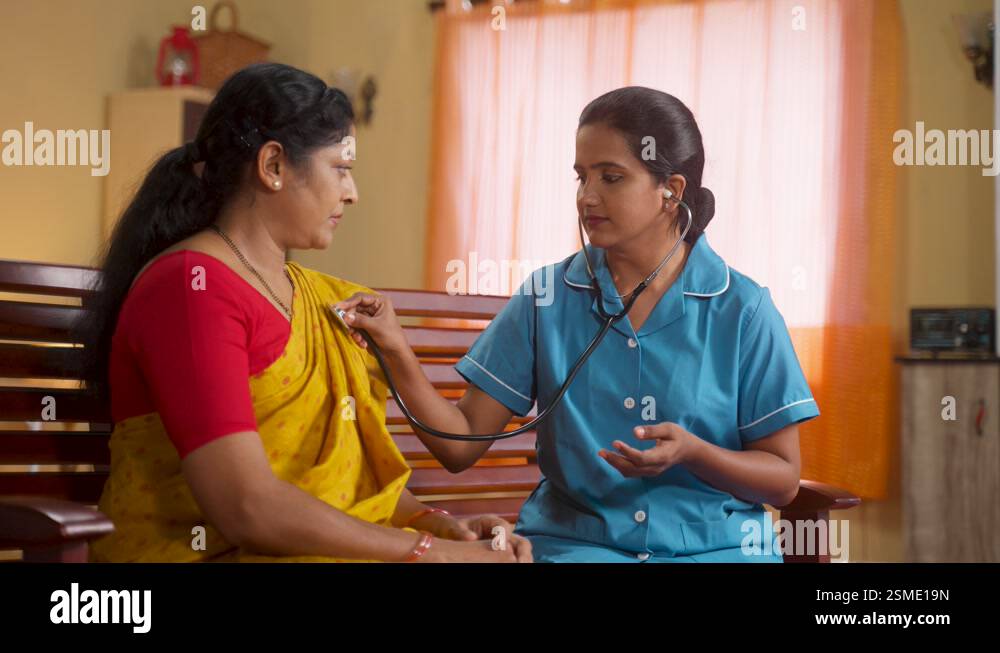 indian nurse or caregiver doing medical check up using stethoscope of ...