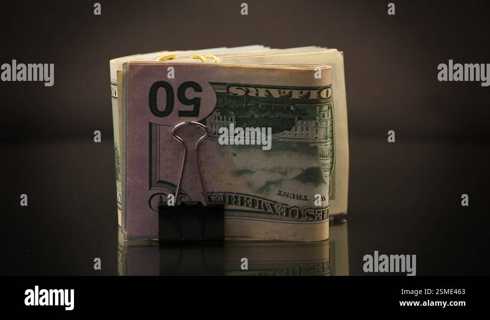 stack of dollar bills collected in an elastic band and a stationery ...