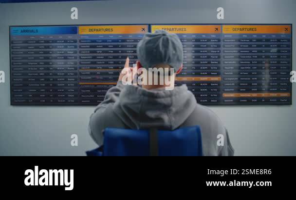 Airport Terminal: Back View of Man with Backpack Checking His Flight on ...