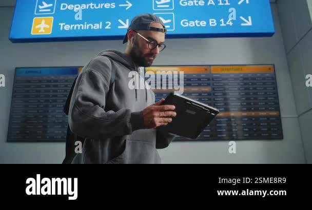 Crowded Airport Terminal: Man with Backpack Uses Tablet Computer ...