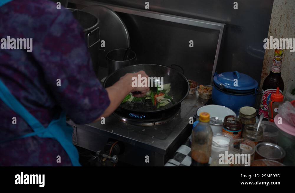 Thai local woman cooking asian traditional street food in dirty small ...