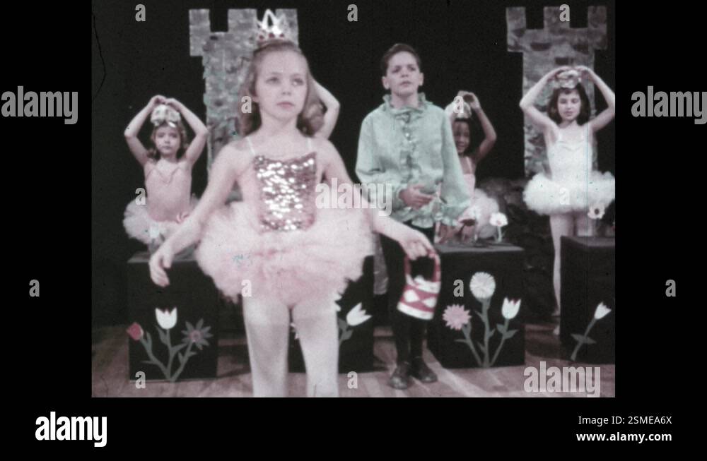 1960s: Stage. Children perform dance. Girl feeds candy to other dancers ...