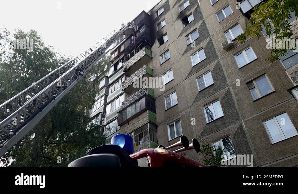 fire truck with flashing lights, extinguishing a fire from the stairs ...