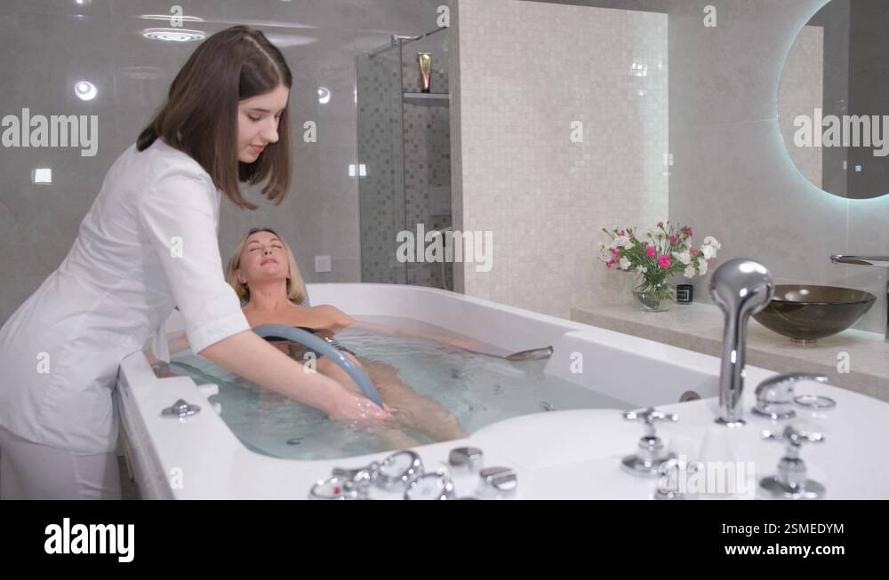 Hydromassage from a professional beautician in the spa center. A woman ...