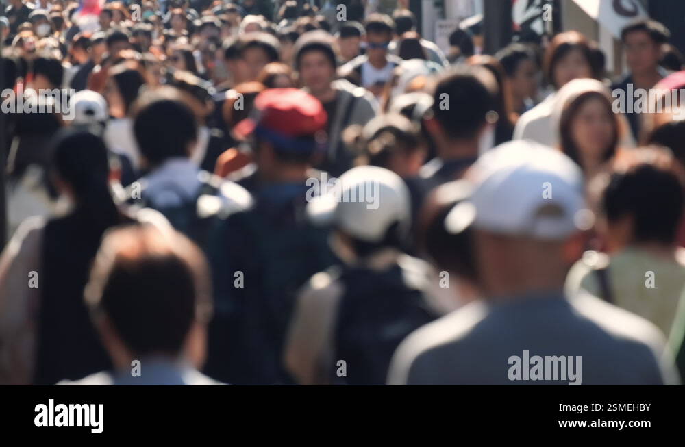 Unfocused blurry crowd of people walking in the street. Slow motion ...