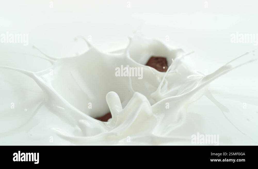 Chocolate Chunks Falling into Creamy Milk Making Swirly Splashes in ...