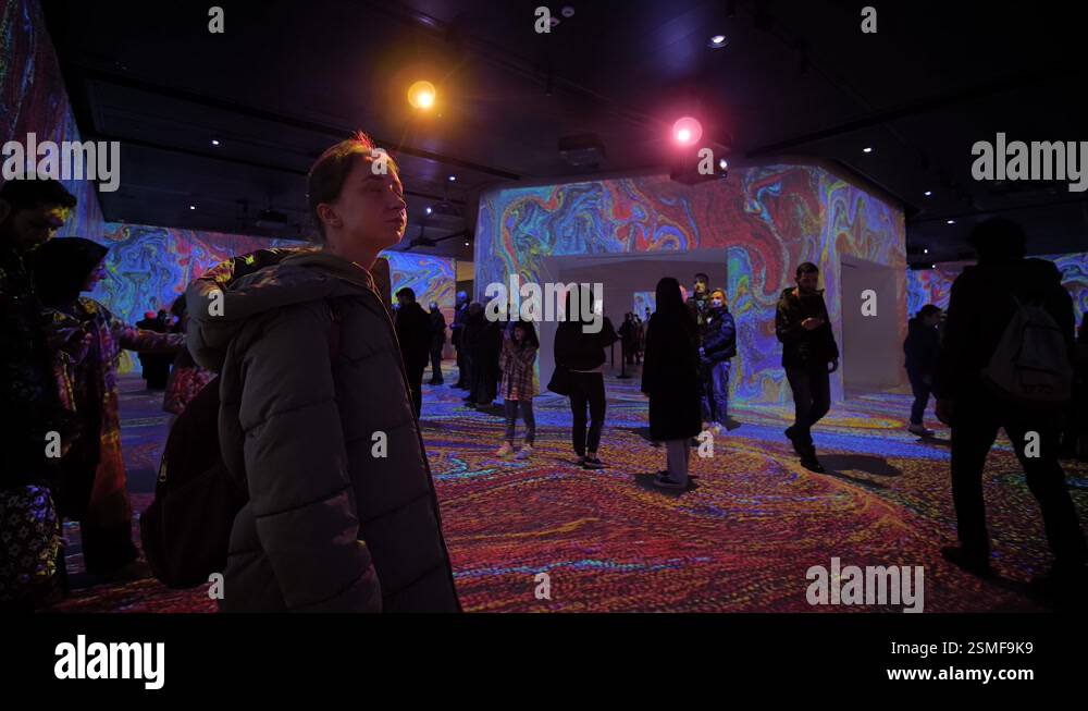 Woman looks around the immersive exhibition - video mapping, people ...