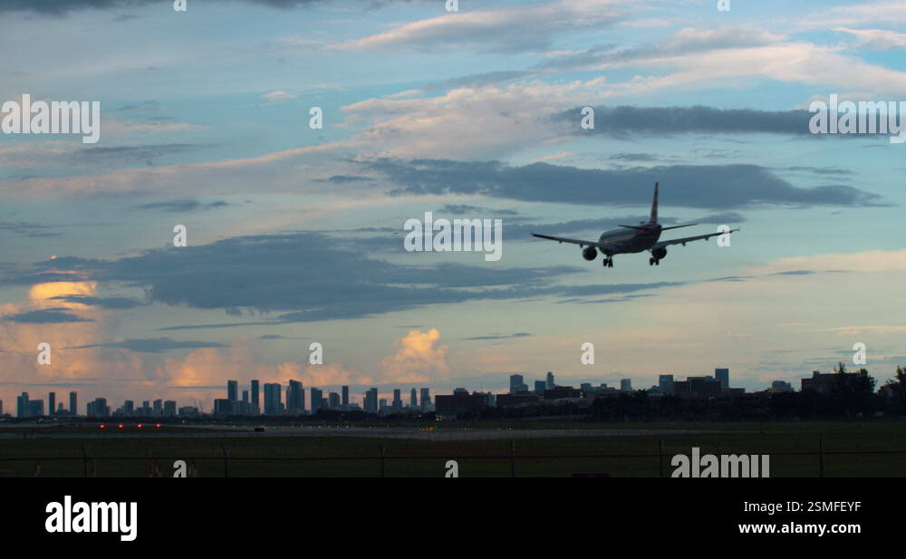 Colorful Sunset Clouds Behind Miami City Skyline with Plane Landing ...