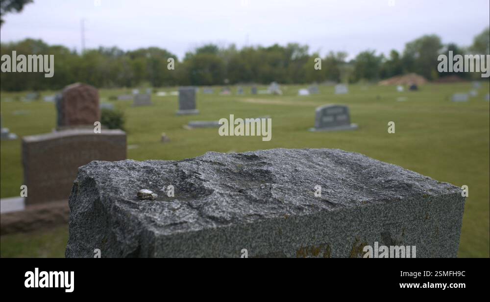 Graveyard tombstones and graves in cemetery on gloomy, cloudy day Stock ...