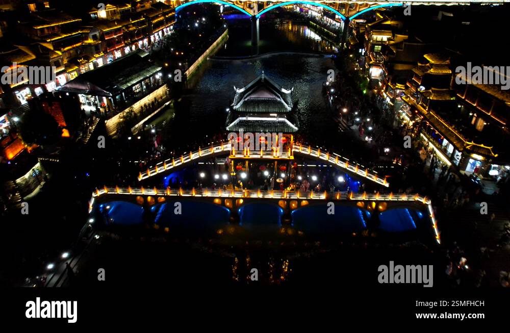 Aerial night reveal shot of illuminated Snow Bridge and Tuo Jiang Stock ...