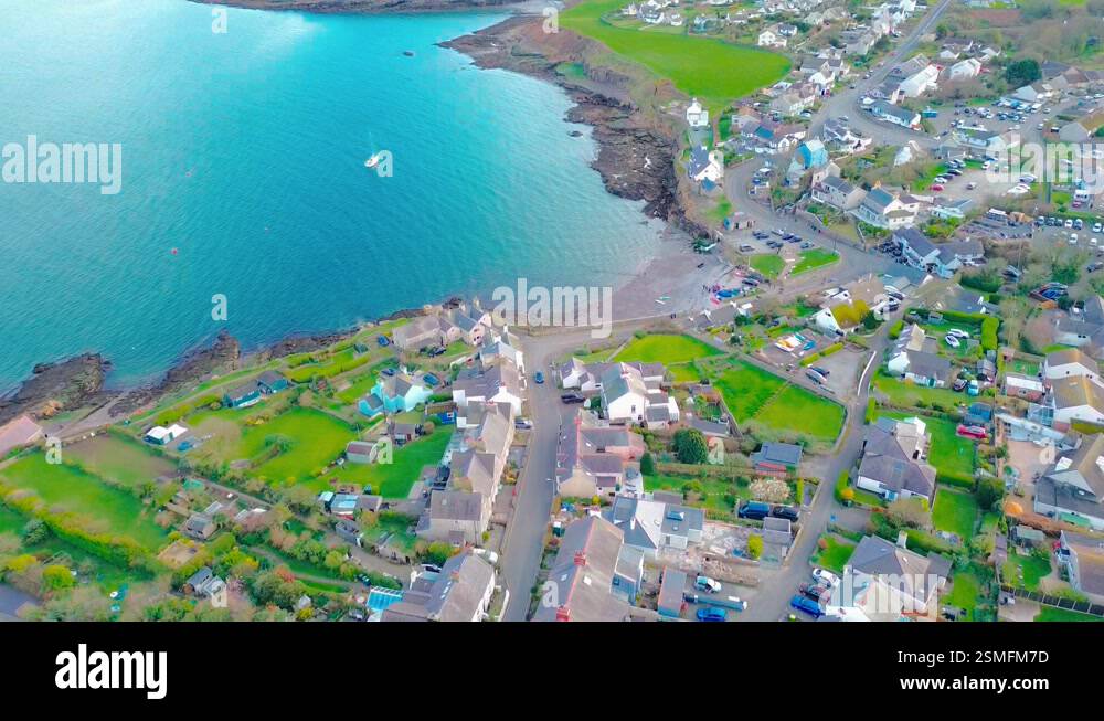 Flying overhead Moelfre village Anglesey, towards the beach with view ...