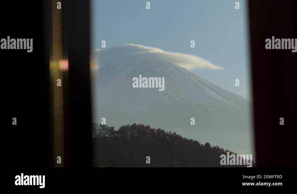Mount Fuji seen through a window with a clear blue sky and light cloud ...