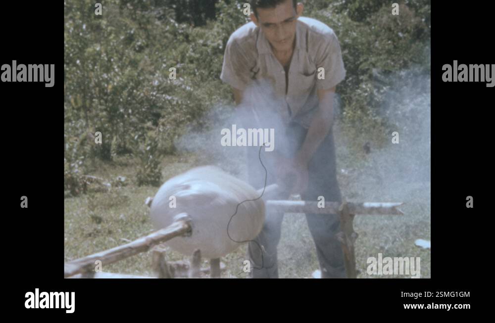 1940s: Man turns object on pole over smoker Stock Video Footage - Alamy