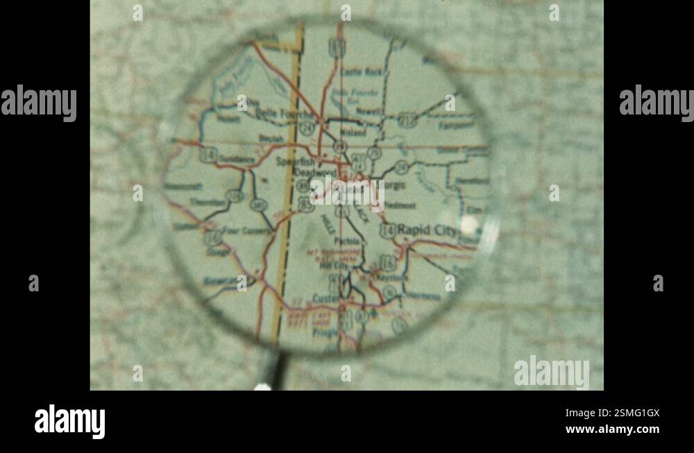 1950s: A road map of the United States. Magnifying glass focuses on a ...