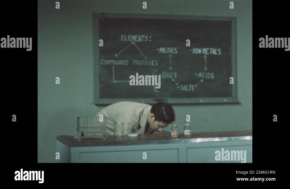 1950s: young man in lab coat looks at diagram on chalkboard near test ...