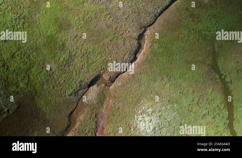 Aerial view of melting glacier river in Iceland with black volcanic ...