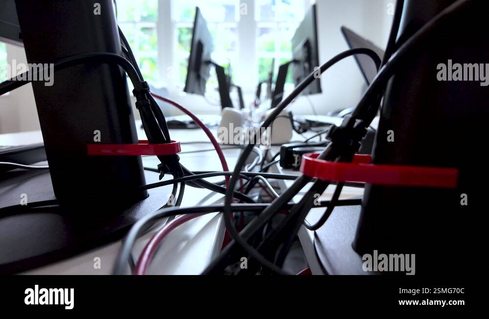 Close-up of office desk setup with cables and wires organized behind ...