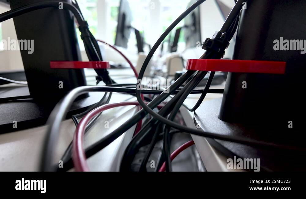 Close-up of office desk setup with cables and wires organized behind ...