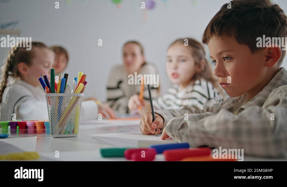 Diligent pupil drawing pencil in school closeup. Focused boy creating ...