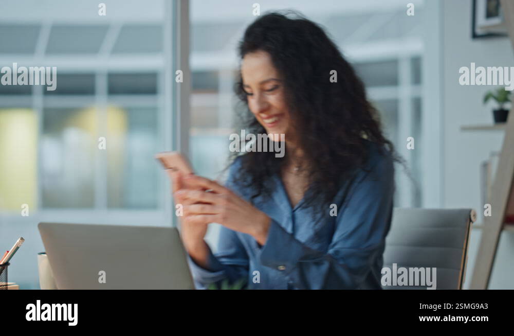 Excited manager receiving message at desk. Busy woman checking mobile ...