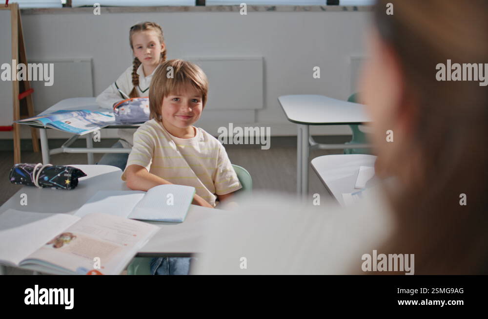 Primary school boy learning classroom. Schoolchildren writing copybook ...