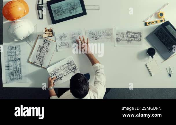 Top down aerial view of architect engineer placing building blueprint ...