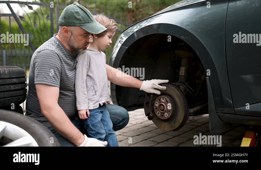 Father teaching his little son motor vehicle construction basics. Slow ...