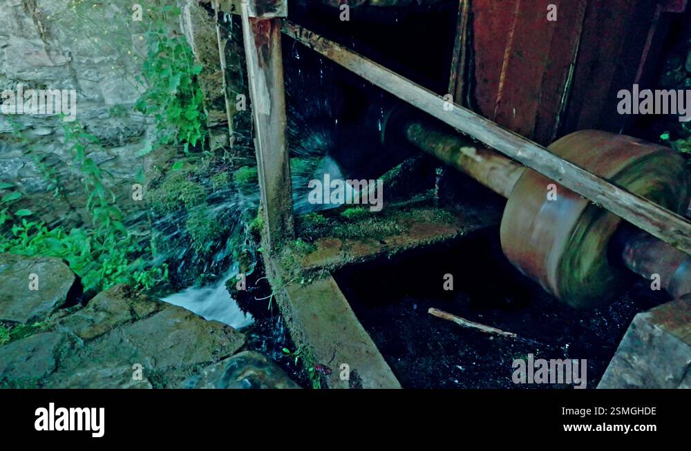 Water power force turns shaft with spinning grindstone at old rustic ...