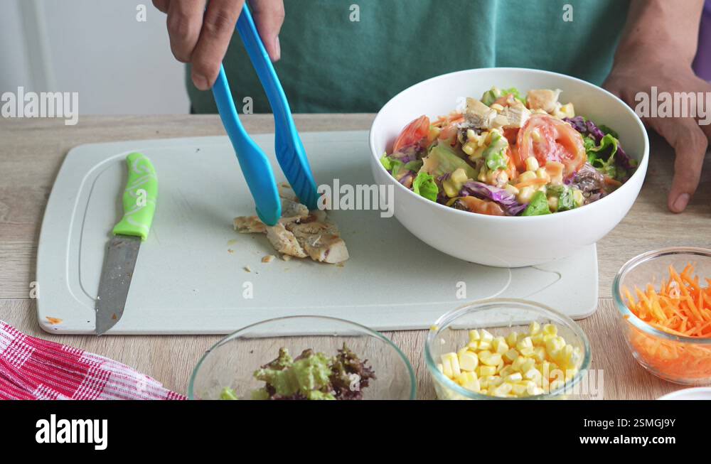 Man Putting Slices Of Cooked Chicken Meat Into Bowl Making Fresh Salad ...