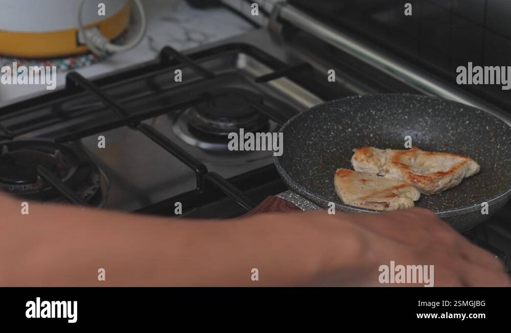 A Man Sniffing Cooked Chicken Meats On Fry Pan On Stove At Kitchen ...