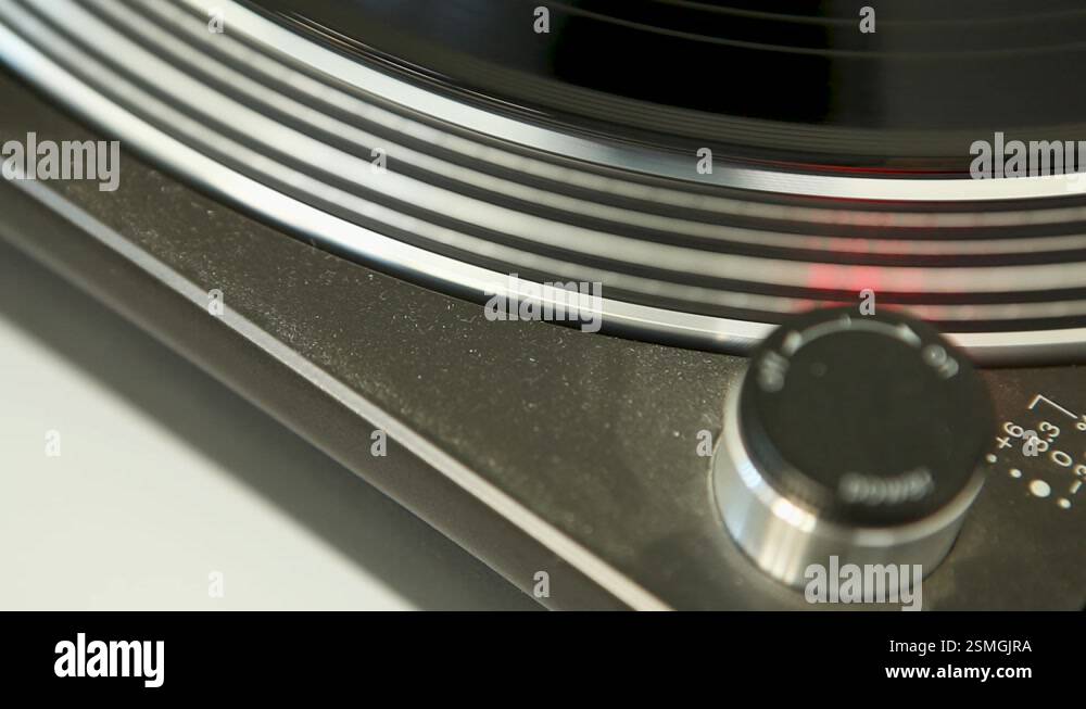 Close-up of a spinning turntable with subtle reflections and warm light ...