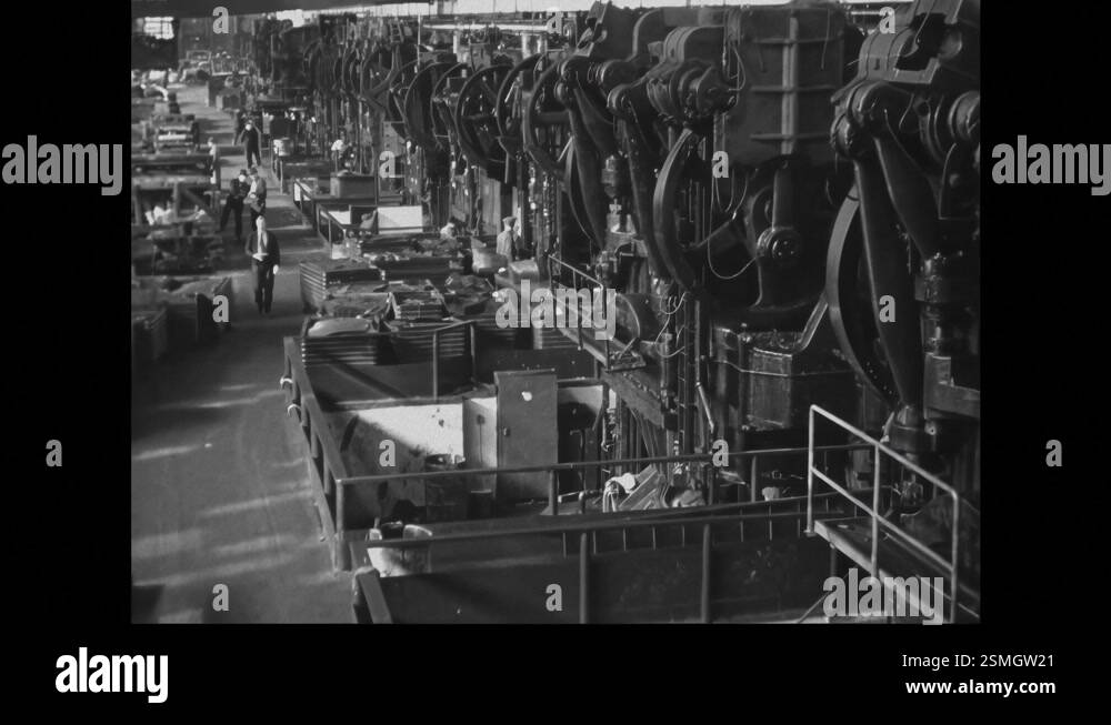 1940s: Workers operate heavy machinery in a factory setting. The ...