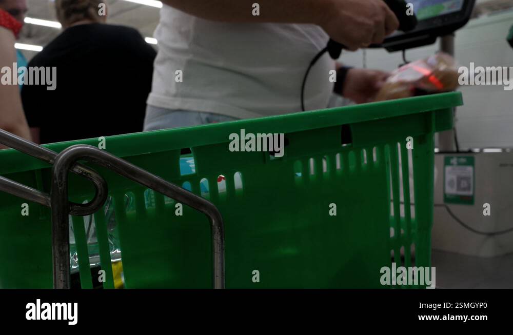 Buyer scanning products at a self-service checkout and pays for her ...