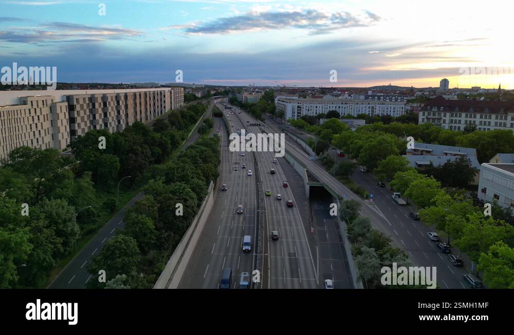 Highway through the city and train at sunset. Nice aerial view flight ...