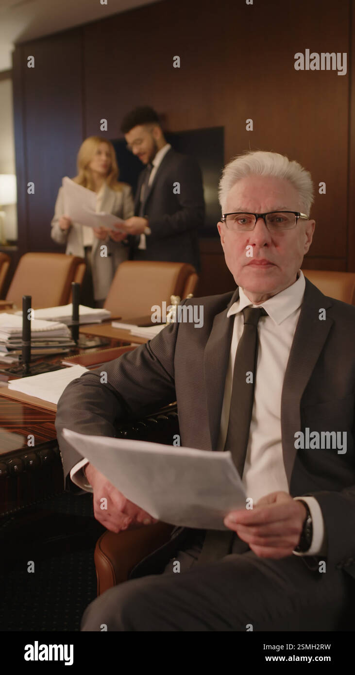 Senior Attorney Holding Documents and Looking at Camera at Boardroom ...