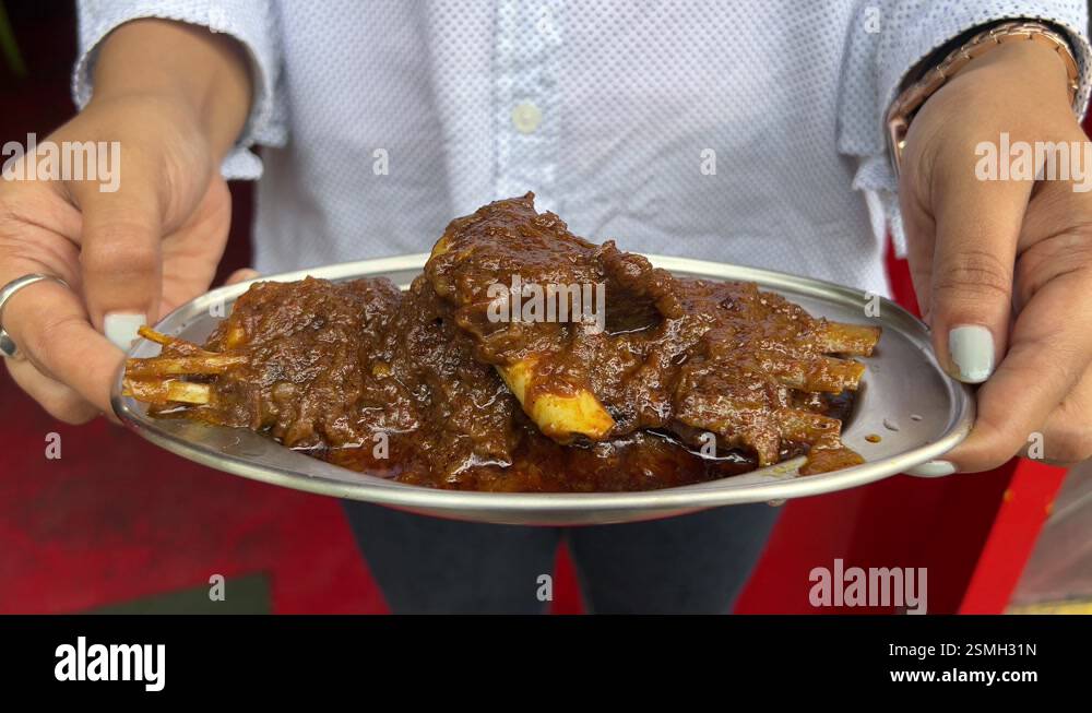 Champaran style spicy handi mutton hold by an Indian girl. No face ...