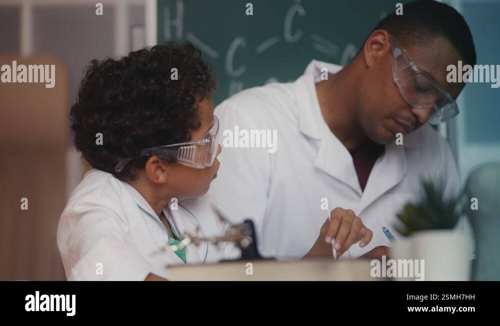 Little boy and dad growing bacteria in a petri dish, conducting lab ...