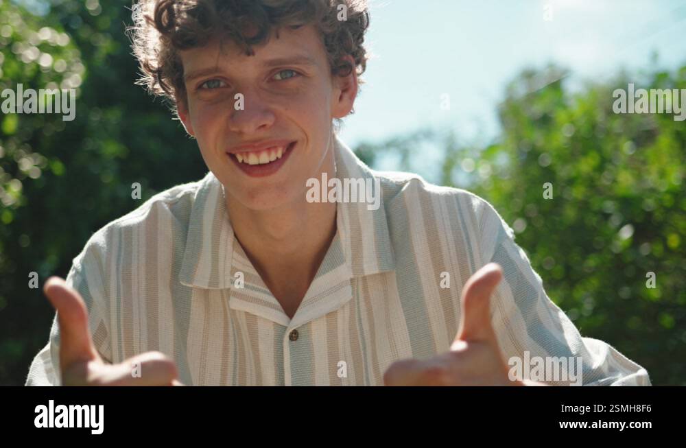 handsome young curly teen boy guy, student showing thumb up with two ...