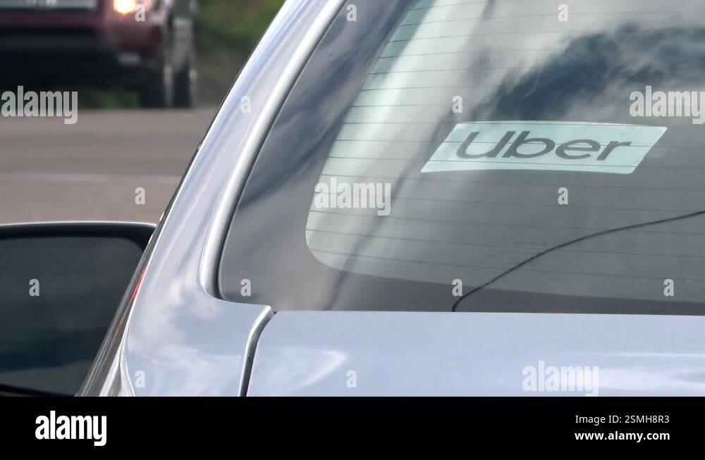 A close-up of an Uber vehicle sticker on a car's rear window, with ...