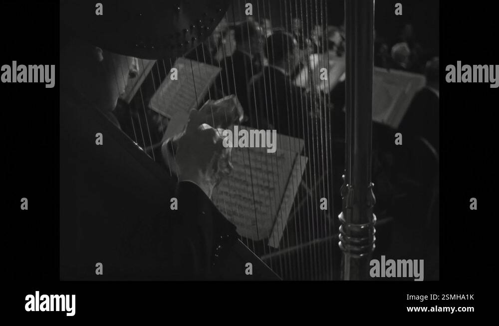 1940s: A musician plays a harp onstage during a concert in the 1940s ...
