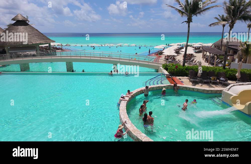 Cancun, Mexico - 07/17/2024: Panning view of a huge swimming pool, with ...