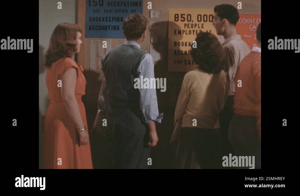 1940s: Four students look at a bulletin board display about accounting ...