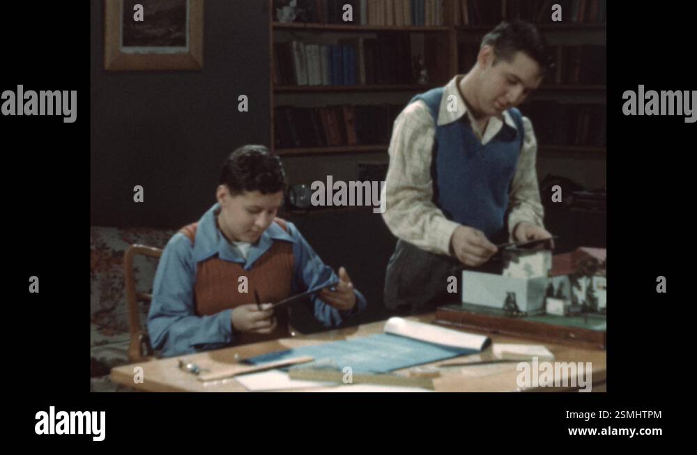 1940s: Two boys, possibly students, have a conversation in a classroom ...
